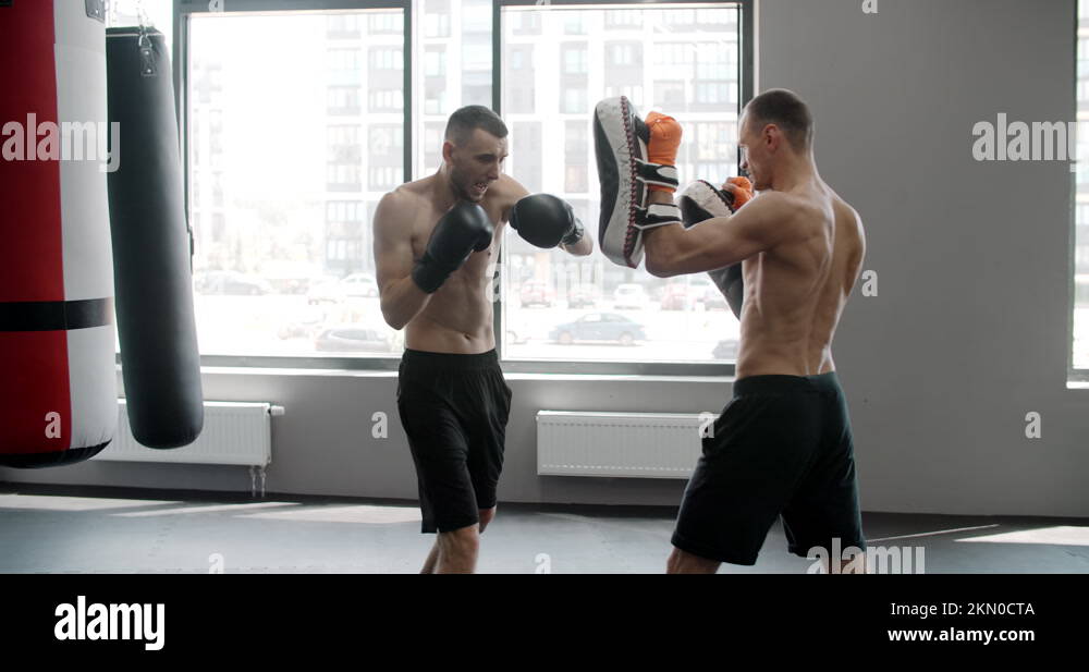 MMA fighter is practising his strikes with trainer in slow motion in ...