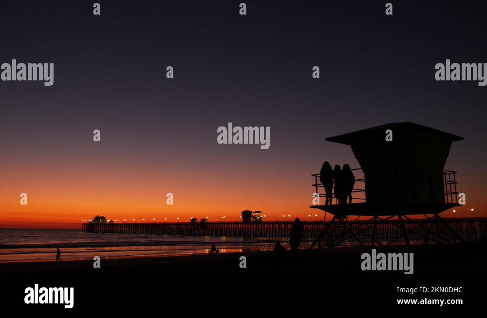 Young teen girls silhouettes, lifeguard watch tower, friends on pacific ...