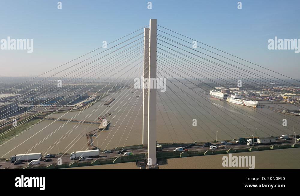 Heavy traffic on highway cable-stayed bridge with tall concrete pylons ...
