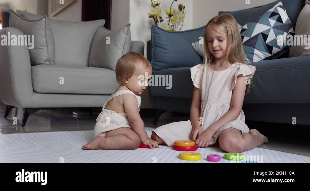 Two cute little caucasian children siblings playing together with ...