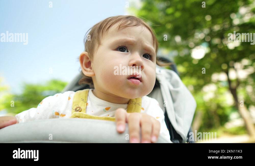Curious little baby girl staring at other kids playing in the ...
