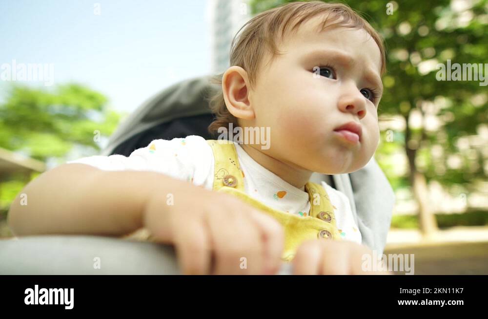 Little 1 year baby girl staring at kids in the playground while she is ...
