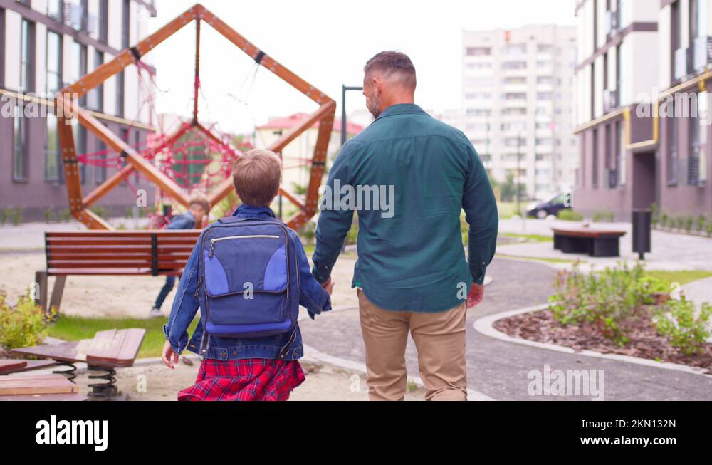 Young handsome dad take his son from school. Beautiful father and boy ...