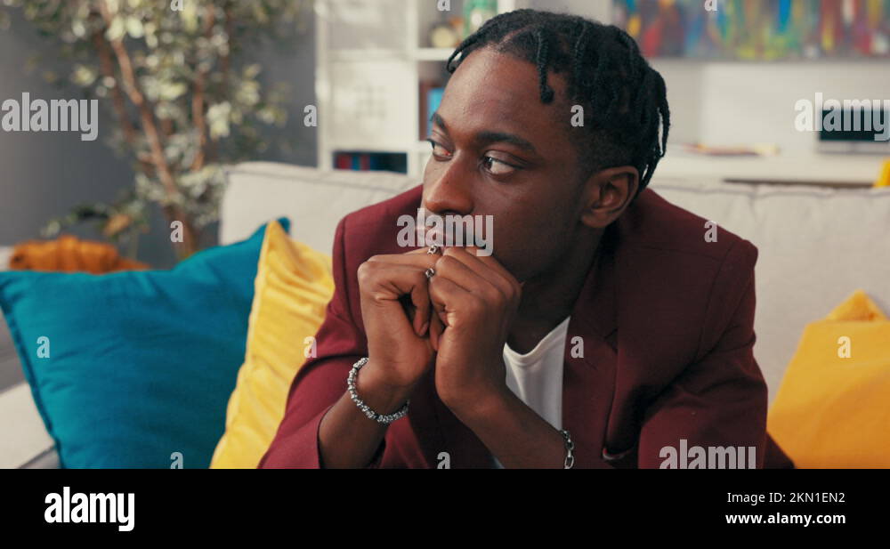 Dark skinned man with dreadlocked wearing smart suit sitting in office ...