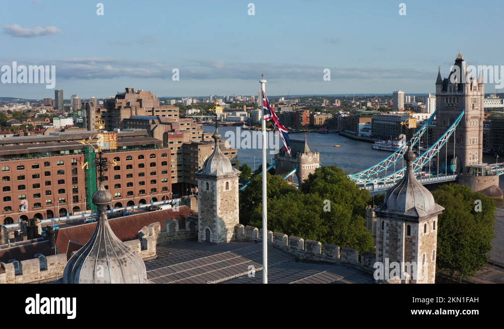 Union Jack slightly waving in breeze. Backwards reveal of white Tower ...