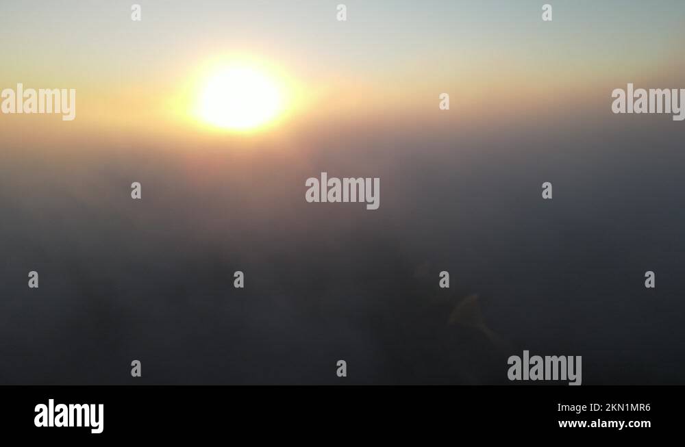 The camera rises through fog clouds to reveal the sunrise. Footage ...