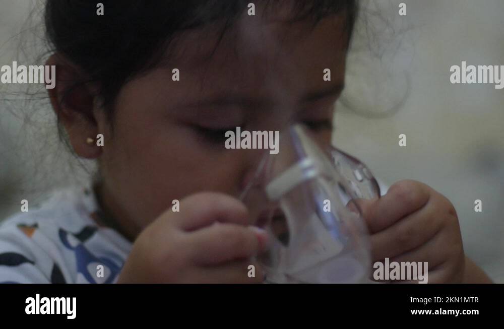 Little girl making inhalation with nebulizer at home. Child asthma ...