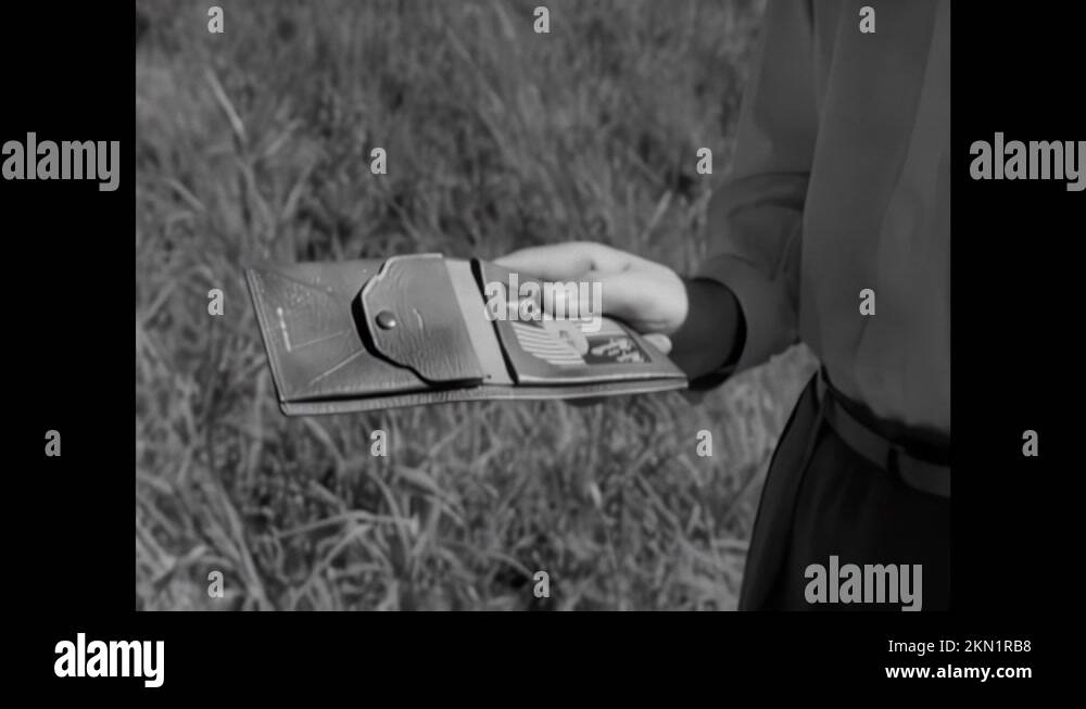 1950s: Boy opens a box and takes out a wallet. Boy approaches another ...