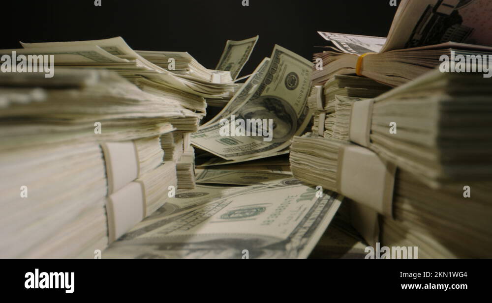 Packs of cash lying on table. 100 US dollars bills chaotically spread ...
