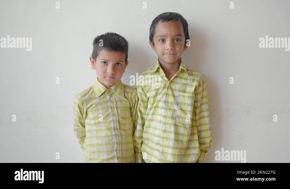 two little adorable primary school children staring at the camera ...