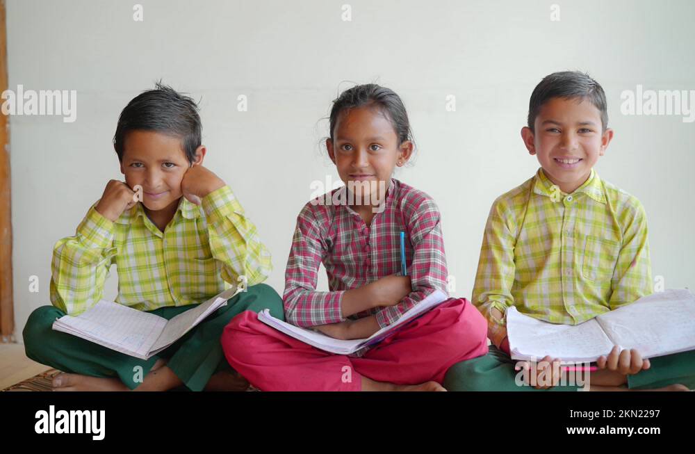 trio indian asian primary school children sitting with books looking ...