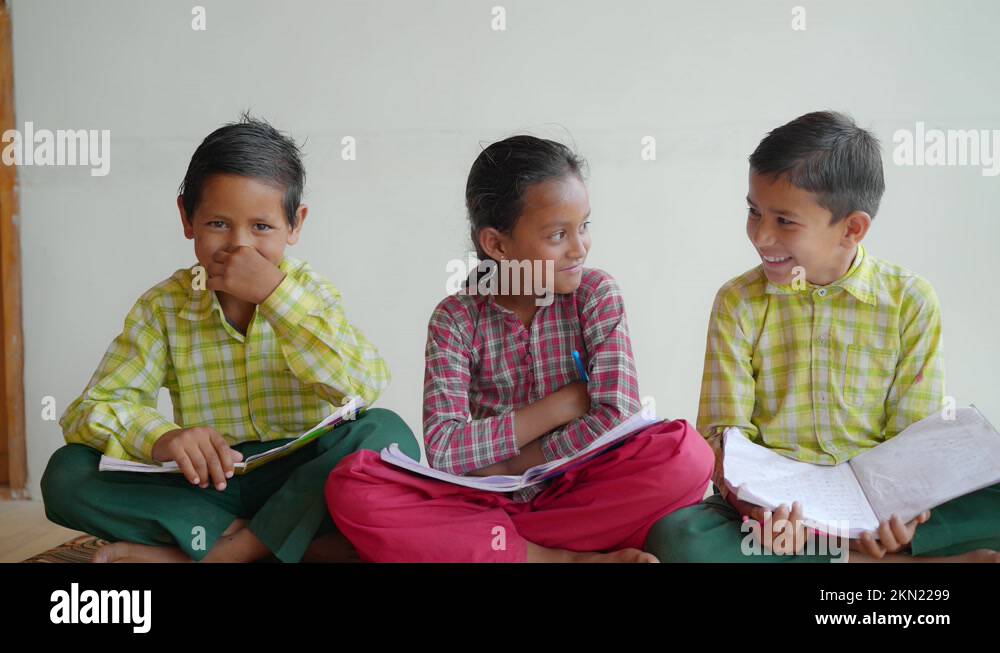 trio indian asian primary school children sitting with books looking ...