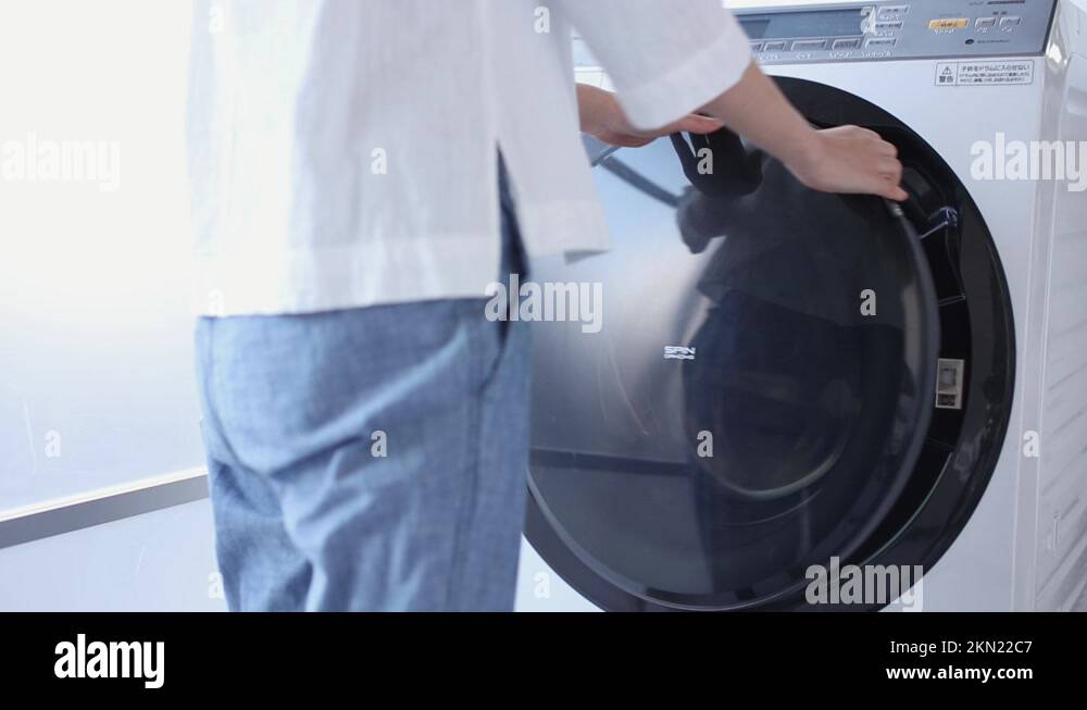 Woman puts laundry in drum type washing machine Stock Video Footage - Alamy