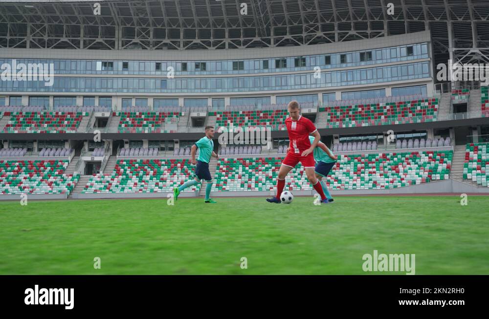 Pro football players play football on a stadium, striker bypasses the ...