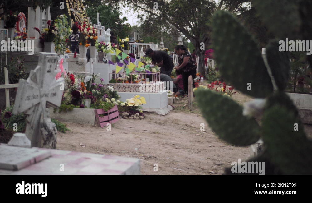 Mexican family visiting their dead relatives at the graveyard during ...