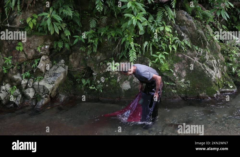 man washing clothes in river Stock Video Footage - Alamy