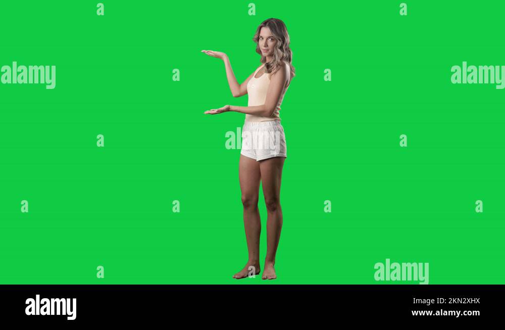 Cute woman in pajamas presenting and promoting. Full body on green ...