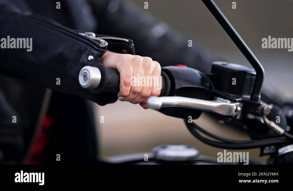 Female motorcyclist hand twists accelerometer lever while standing at ...