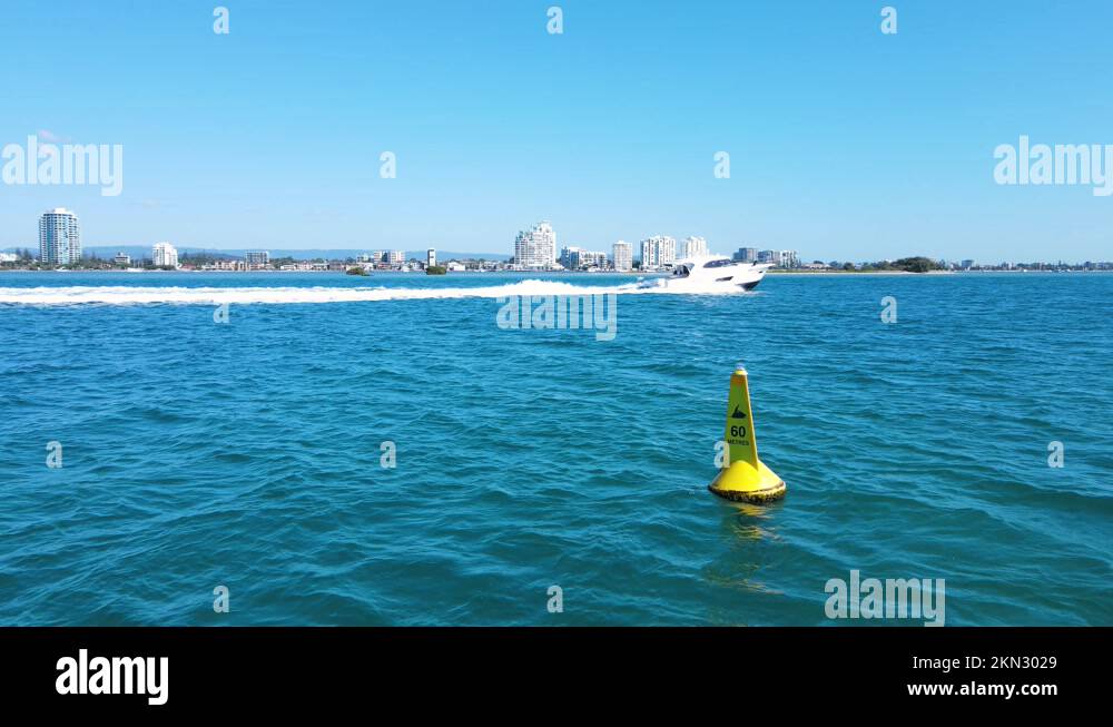 Large boat passes a marine speed limit marker buoy anchored in a major ...