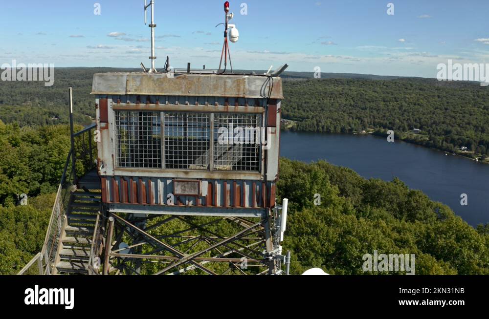 Drone shot rotating around rusty lookout tower will cell equipment ...