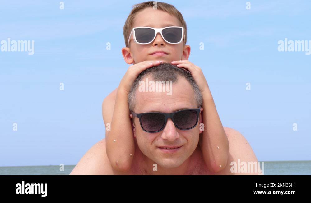 Dad and baby. The boy is sitting on his father's back. A happy family ...