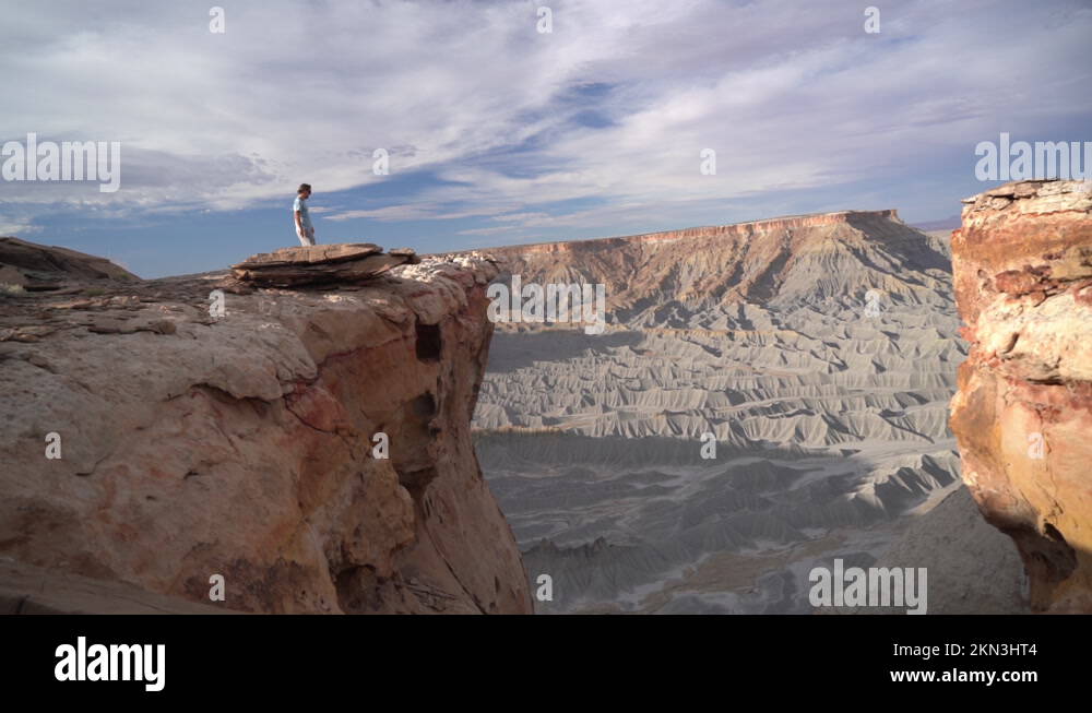 Man Walking on Top Of Mesa Above Abyss and Stunning Surreal Dry Desert ...