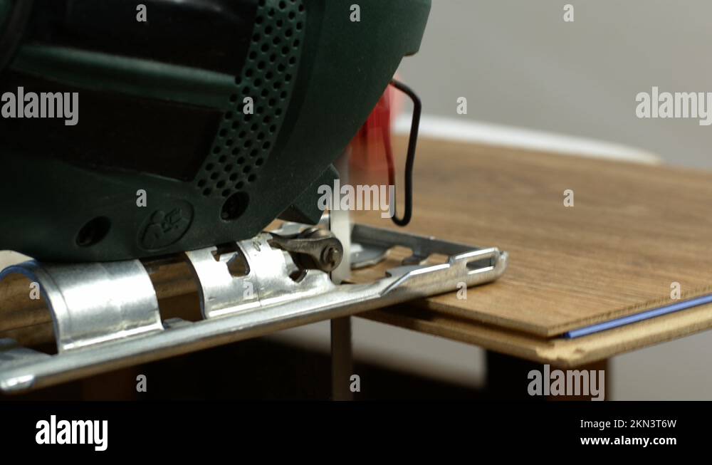 A carpenter cuts wood with an electric jigsaw. Repair work, wood sawing ...
