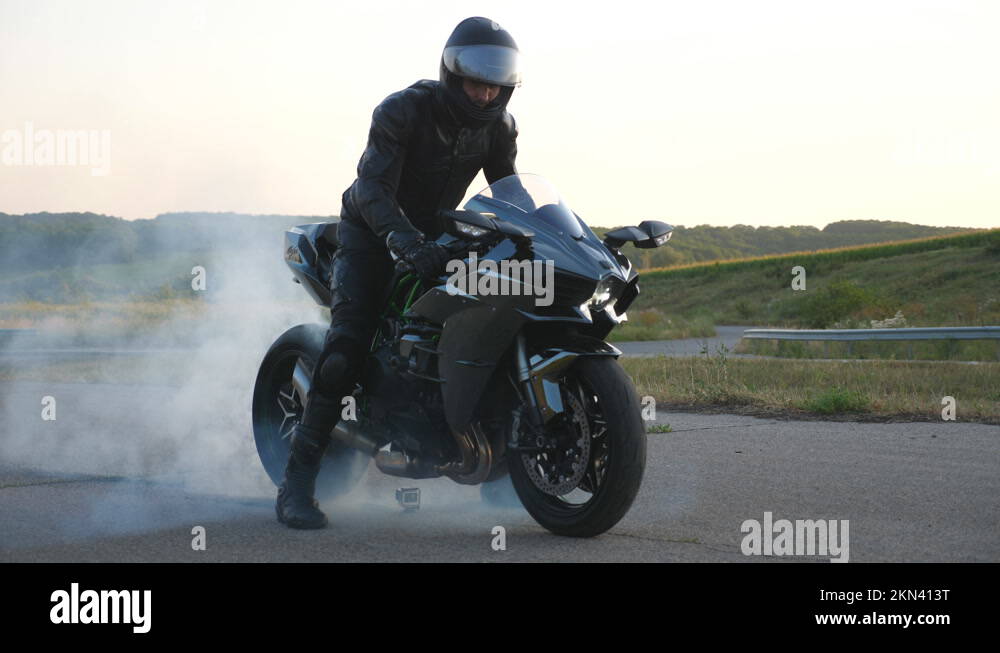 Biker performing tire burnout with lots of smoke. Motorcycle wheel are ...