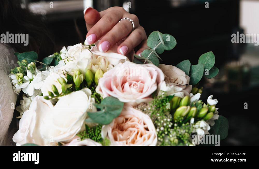 A girl with a ring on her finger strokes the surface of a bouquet of ...