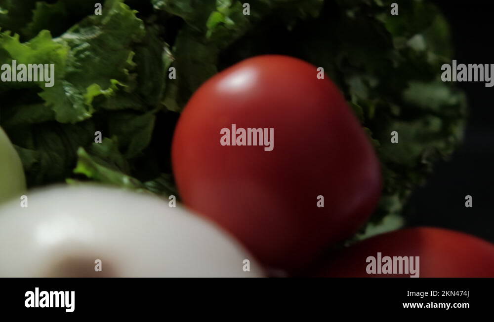 Fresh tomato rolling down from big lettuce with black background Stock ...