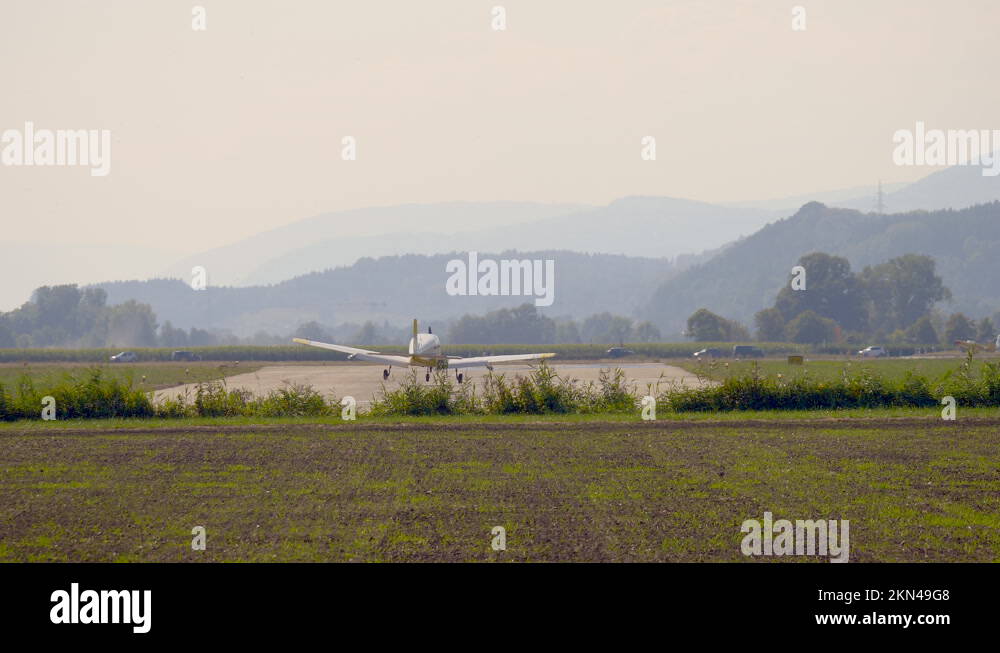 Rear view of hobby light aircraft with propeller landing on small ...