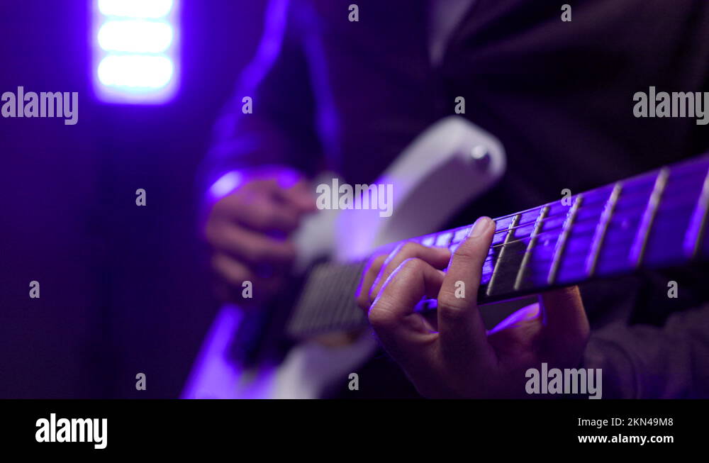 Close up hands young man rocker playing electric guitar on stage live ...
