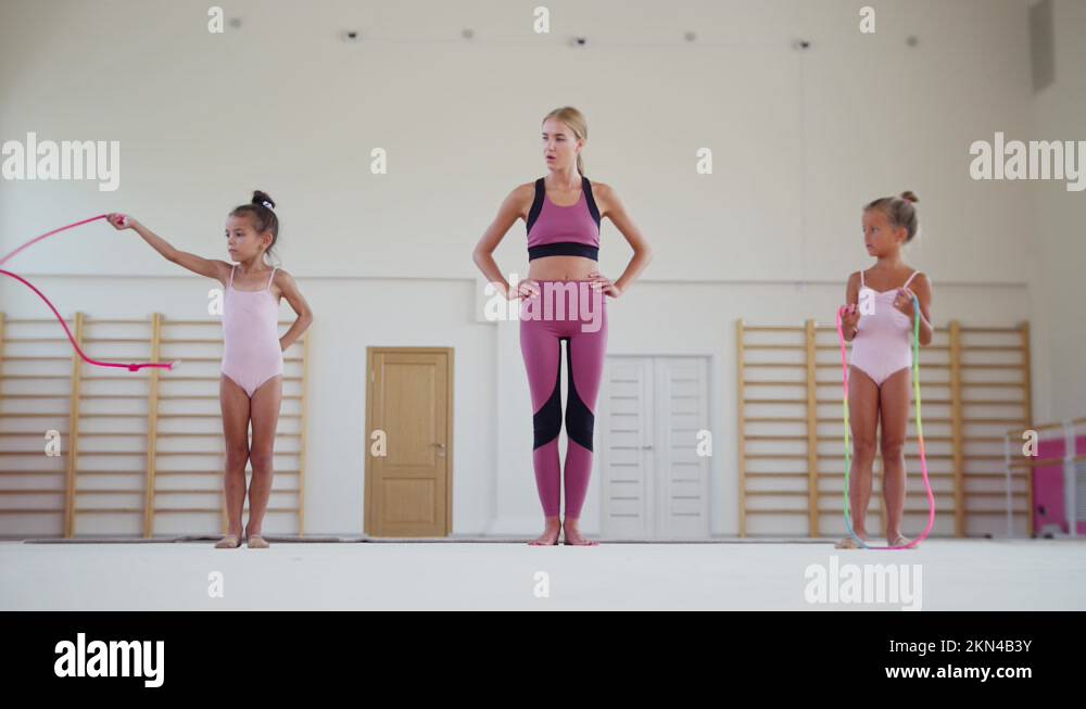 Gymnastic training - female trainer and her two little girls students ...