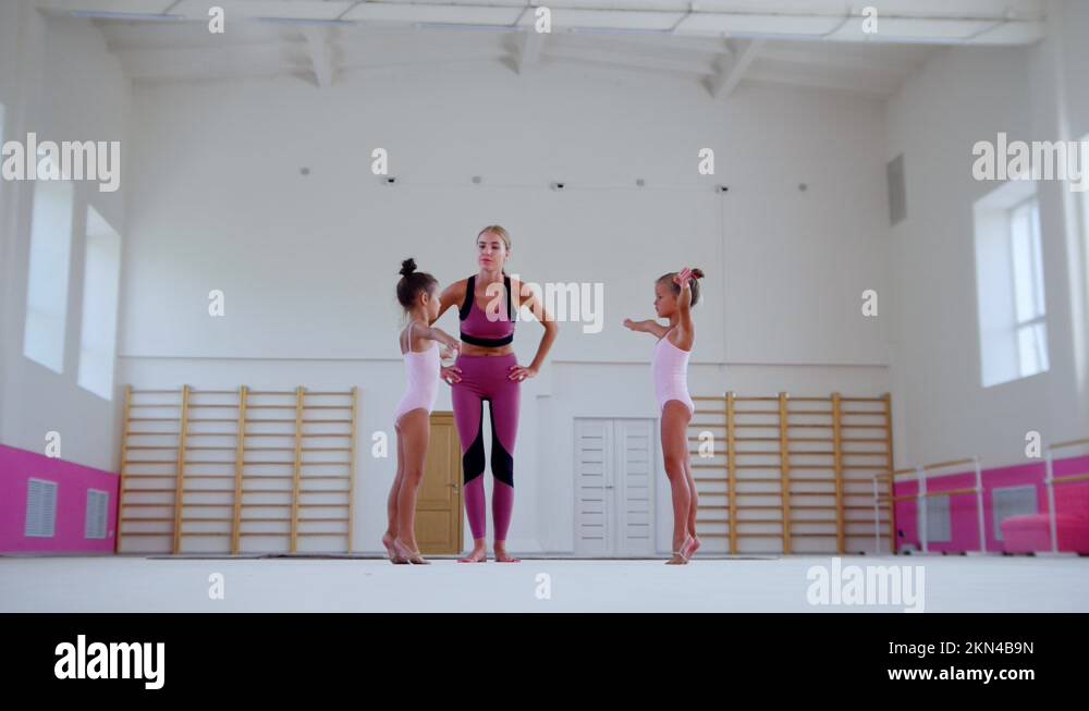 Gymnastic training - female trainer and her two little girls students ...
