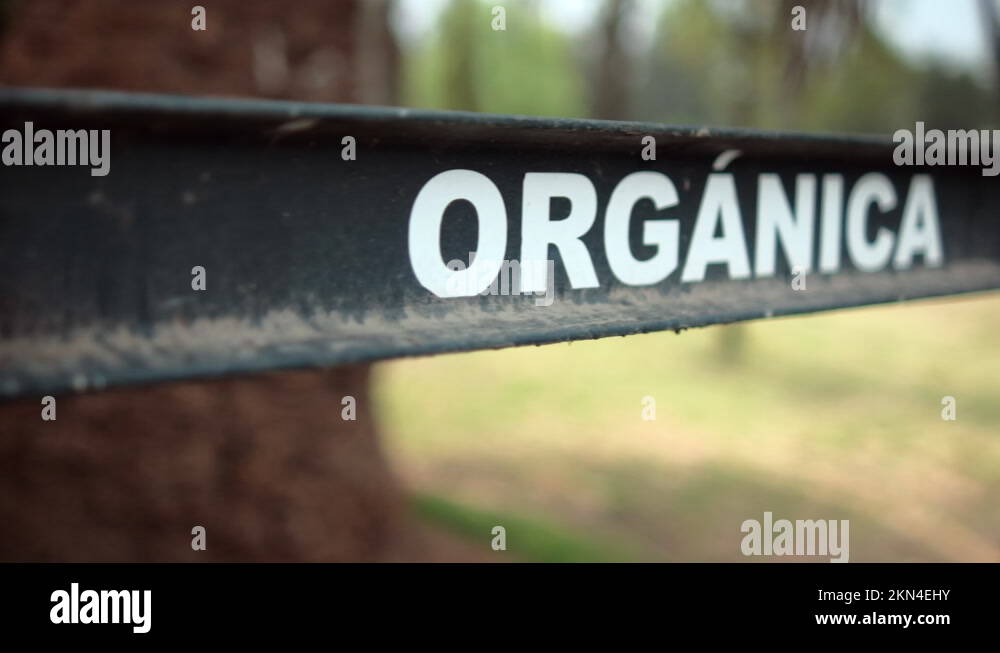 Spanish sign for organic and recyclable trash with blurry trees as ...