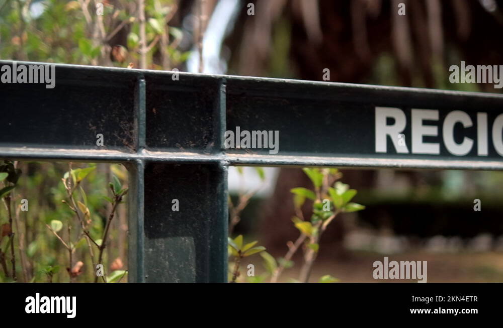 Spanish sign for organic and recyclable trash with trees as background ...