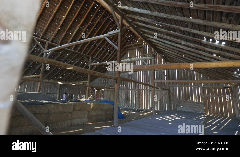 Sideways tracking footage left to right of an empty barn with exposed ...