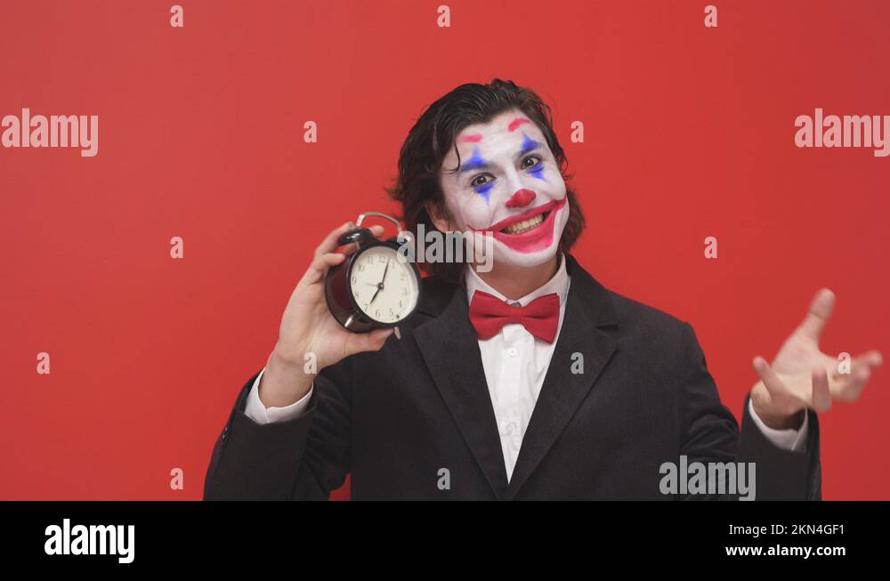 an ugly clown, dressed in a black costume and makeup for Halloween ...