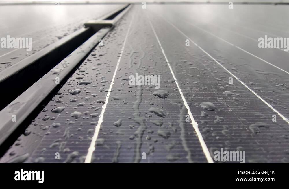 Rain dripping gently on solar panel with silicon solar cells and drops ...