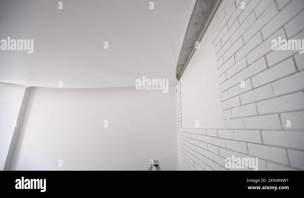 repairmen install stretch ceiling made of pvc vinyl film using a gas ...