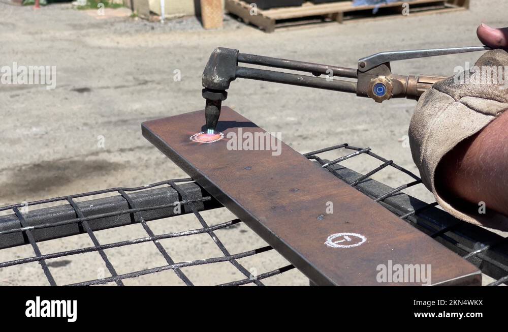 Heat shimmering off a gas welding torch as it cuts a hole in a steel ...
