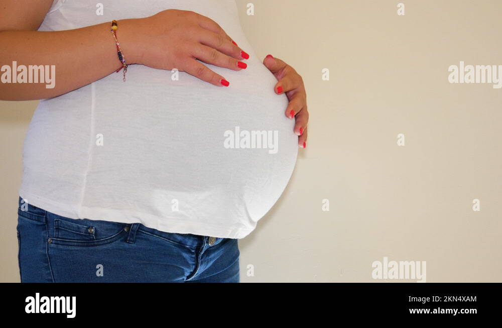 Massive belly with a baby inside of young mother, side static view ...