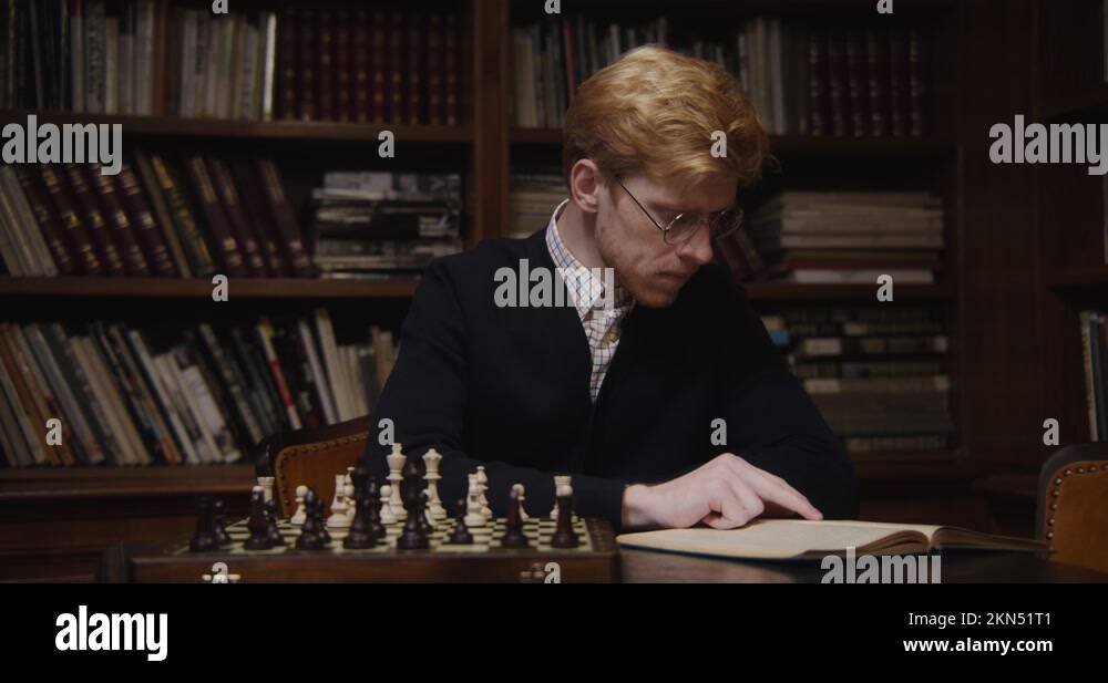 A man is studying with concentration to play chess alone, using a ...