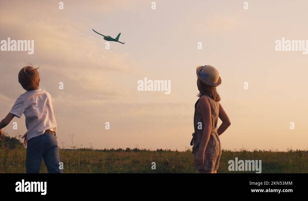 Brother and sister run plane at sunset. Silhouette of children playing ...