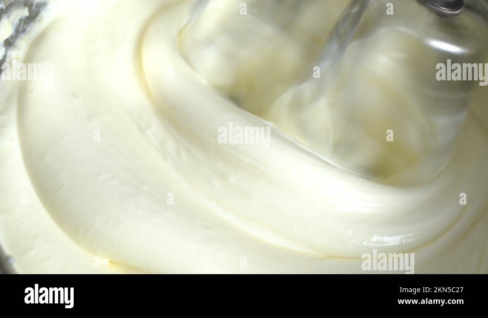 The woman chef whips the ingredients for baking with a mixer. Whipped ...