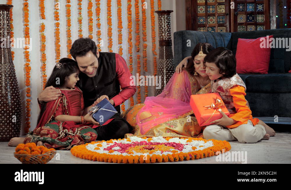 An Indian couple giving gifts to their son and daughter on the occasion ...