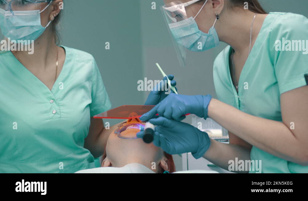 Applying insulating gel on gums and his photopolymerization lamp Stock ...