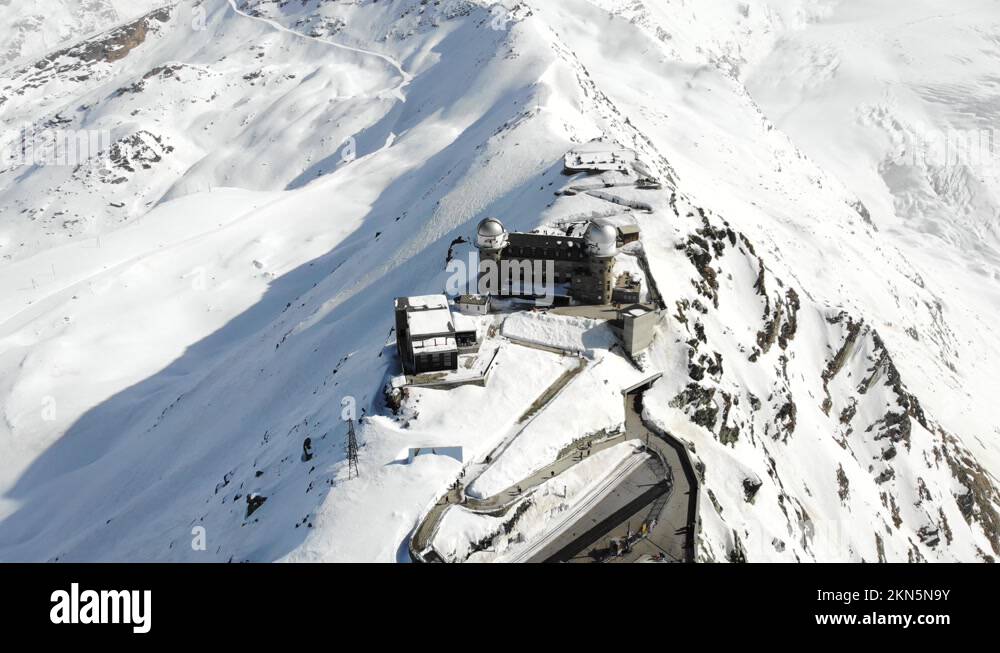 Aerial flyover over Gornergrat train station with pan up towards the ...