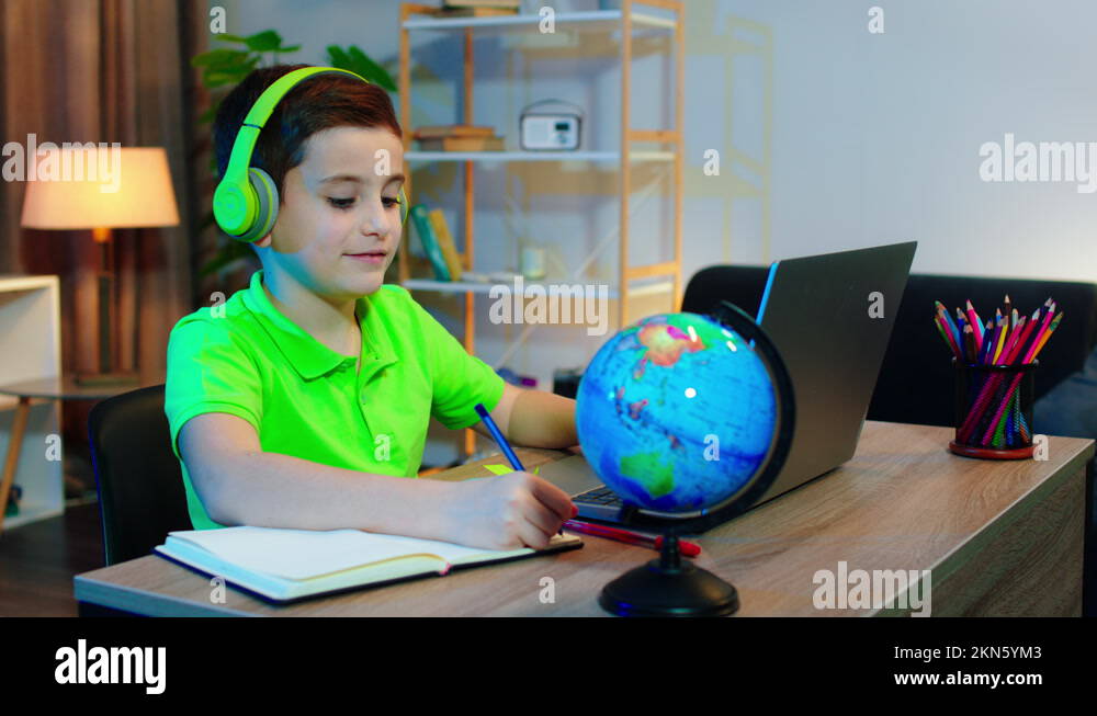 In the living room concentrated pretty boy doing his online classes ...