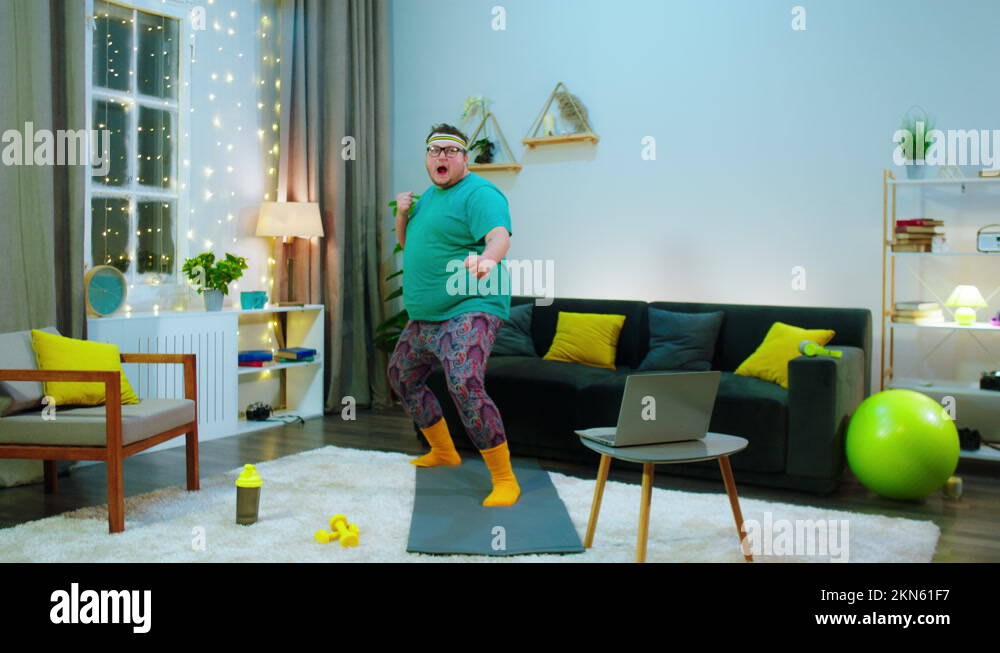 A jolly fat man is in a modern looking room, he is doing karate and ...